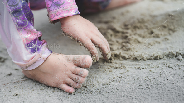 Close Up portrait of kids feet and hand playing with sand. Sensory ...