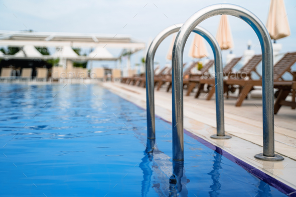grab bars outdoor swimming pool entrance with sunlounger chairs terrace ...