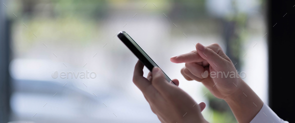 Close up girl pointing finger on screen smart phone on blur background ...