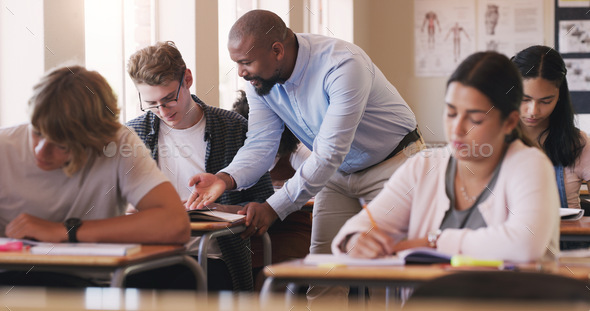 Shot of teenage boy asking his teacher for help during an exam in a ...