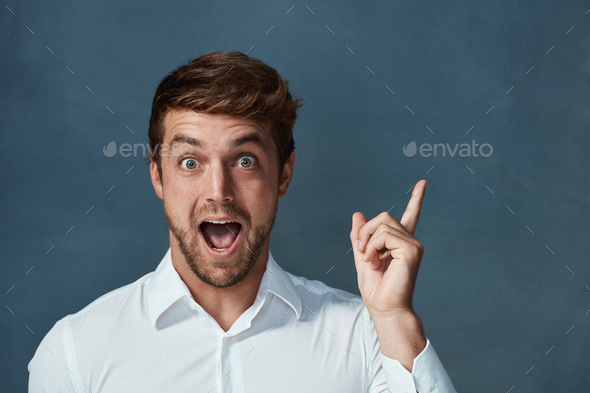 Studio portrait of a handsome young man pointing excitedly to copyspace ...