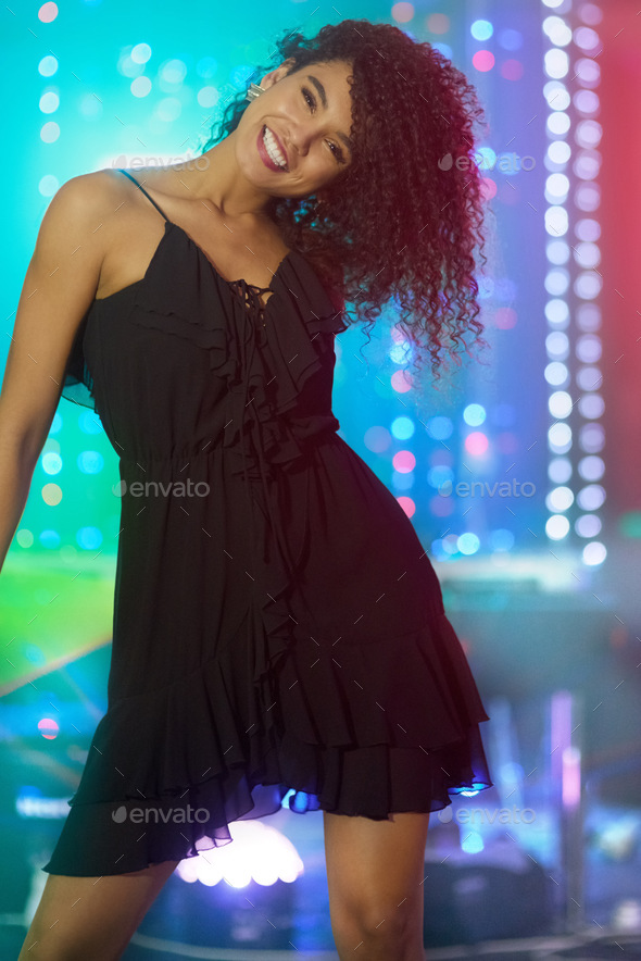 Moving to the music. Shot of a beautiful young woman dancing in a ...
