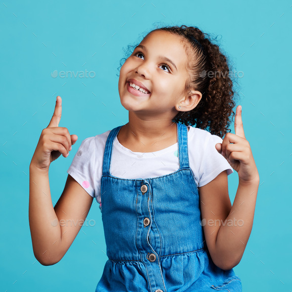 Shot of an adorable little girl pointing at something while standing ...