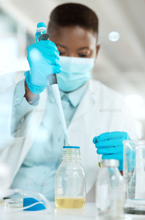 Shot of a young scientist sitting alone in her laboratory and testing ...