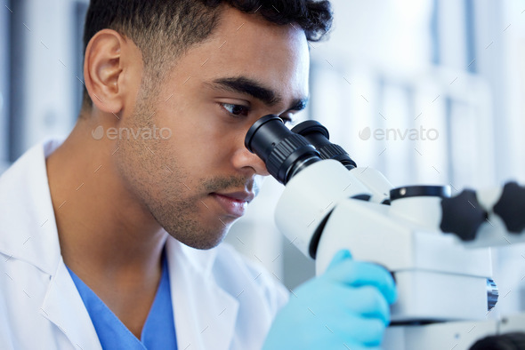 Theres a lot to observe in science. Shot of a young man using a ...