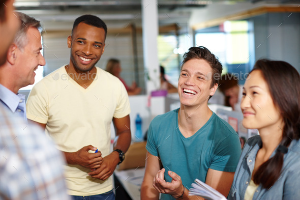 Shot of a diverse group of coworkers enjoying a friendly conversation ...