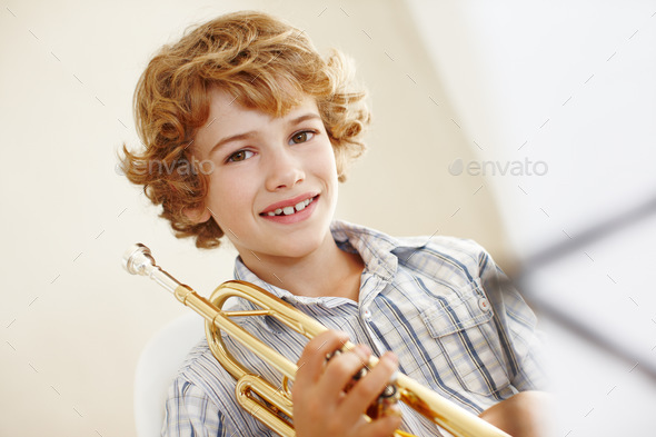 Music makes me happy. Shot of a cute little boy playing the trumpet ...