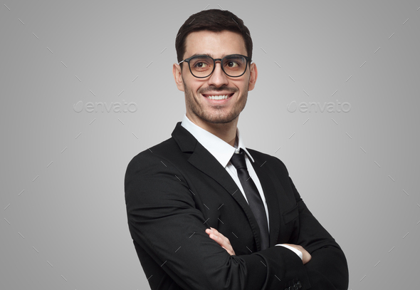 Horizontal shot of young successful smilling business man with crossed ...