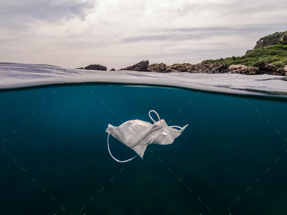 Medical face mask floating underwater. Used surgical mask on ocean ...