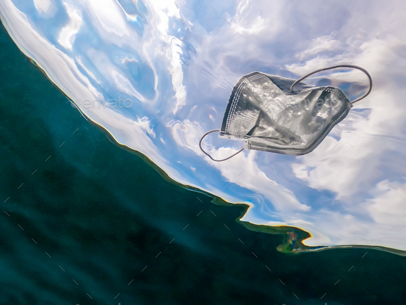 People throws out a medical face mask floating underwater on ocean ...