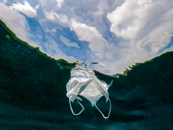 Medical face mask floating underwater. Used surgical mask on ocean ...