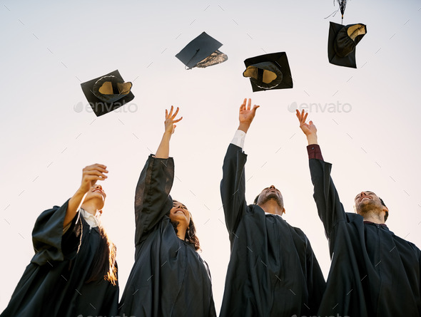 Shot of a group of students throwing their hats in the air on ...