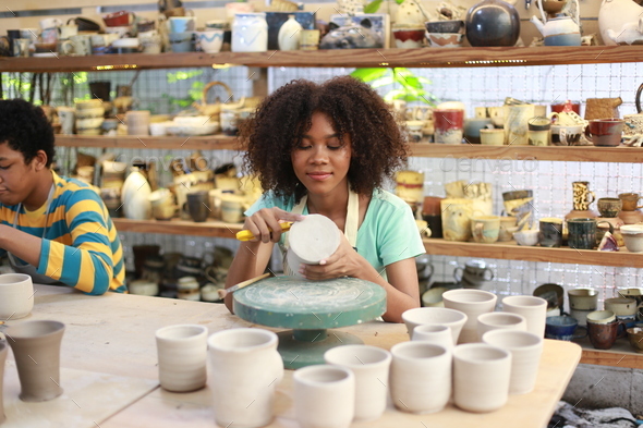 Ceramic artist painting exterior surface of pottery piece Stock Photo ...