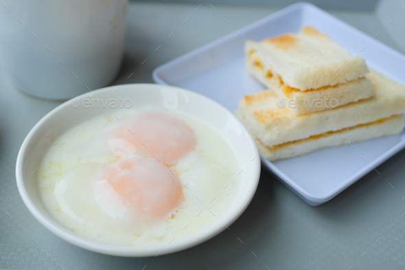 half boiled egg, toasted bread and tea on table Stock Photo by towfiqu98