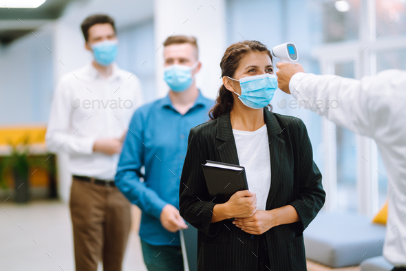 Office staff undergo temperature screening at the entrance. Business ...