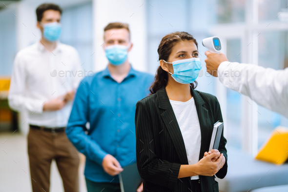 Office staff undergo temperature screening at the entrance. Business ...