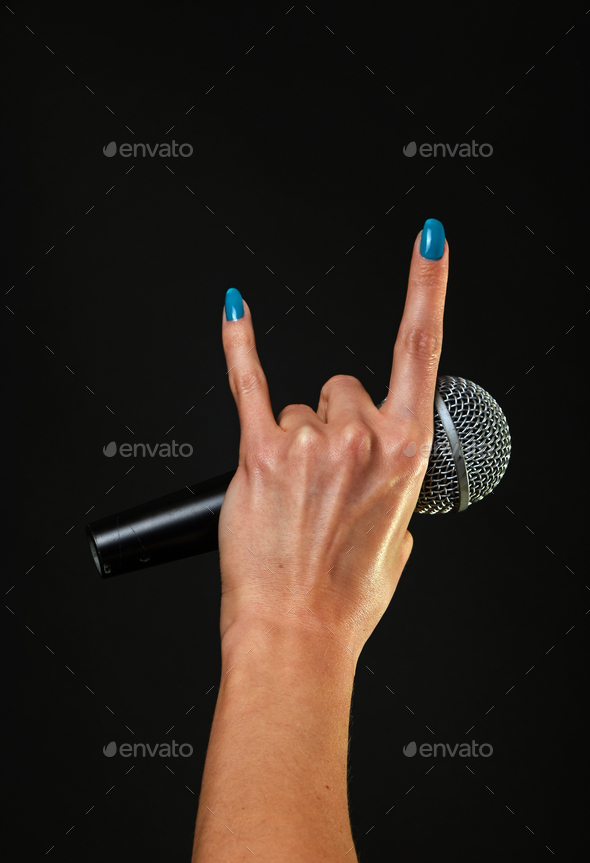 Woman hand with microphone and devil horns isolated on black Stock ...