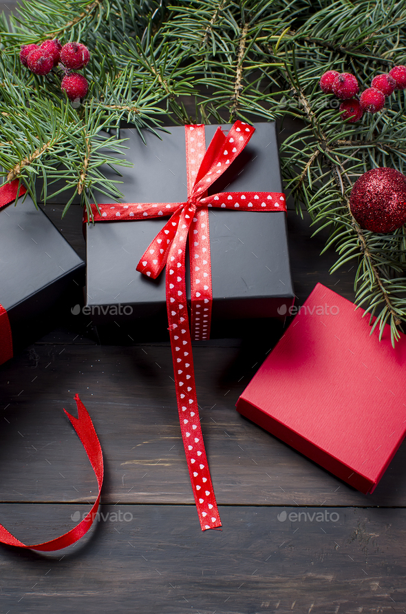 Red christmas gift box with red ribbon and fir branches Stock Photo by ...