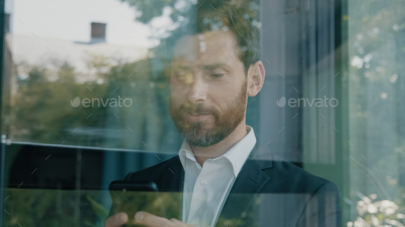 Close up reflection in glassy window blue glass Caucasian bearded 40s ...