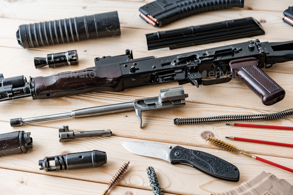 Disassembled rifle with cleaning tools on table of weapons workshop ...