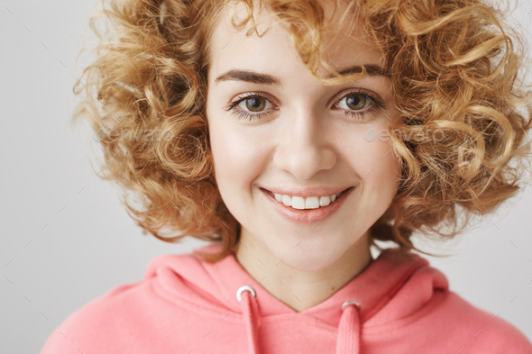 Close-up portrait of charming sunny girl with fair curly hair, smiling ...