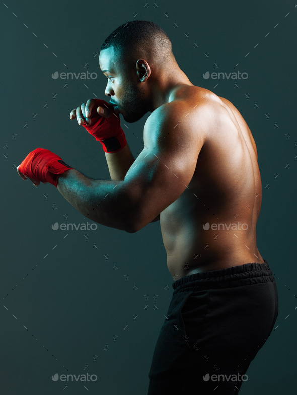 Stand back, hes about to strike. Shot of a handsome young man boxing ...