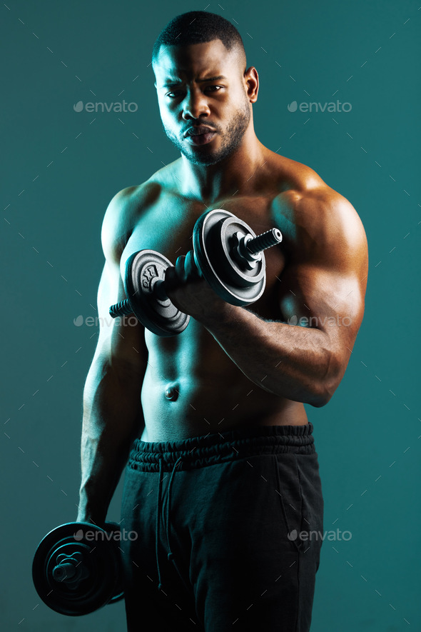 Lift it like you mean it. Shot of a handsome young man lifting weights ...