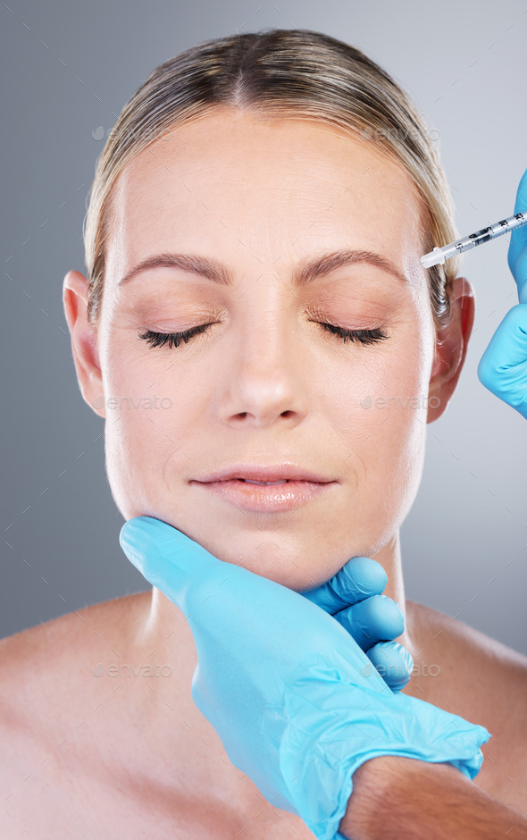 Studio shot of an attractive mature woman receiving a botox injection ...