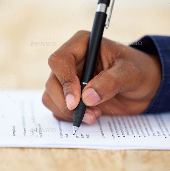 Shot of an unrecognisable businessman filling in a form on a desk in an ...