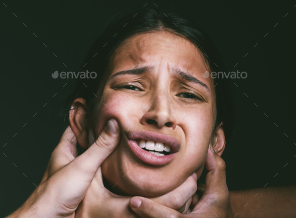 Shot of hands grabbing a young womans neck against a dark background ...