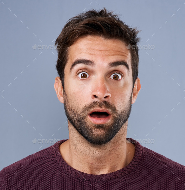 What is that. Studio shot of a handsome young man looking surprised ...