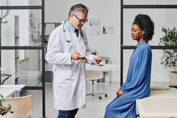 Therapist explaining treatment with patient Stock Photo by AnnaStills