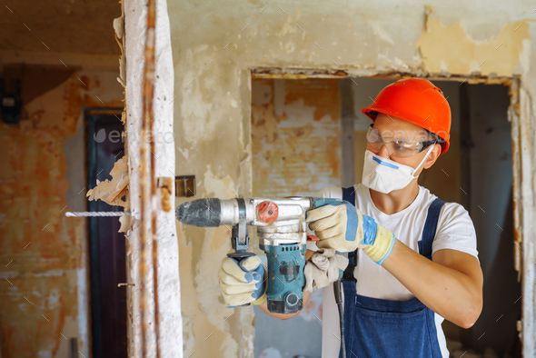Repairer in boilersuit holding tools. Apartment repair and renovation ...