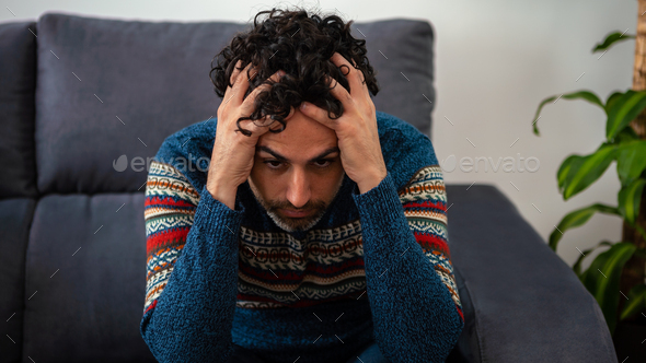 Handsome male model feels tired after work. Man holding his forehead on ...