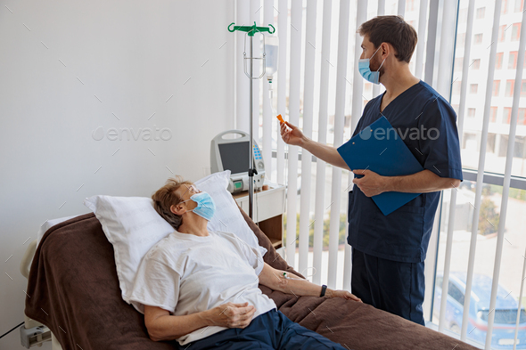 Doctor controls drip of her patient in mask during Covid-19 epidemic ...