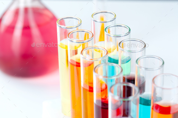 Colored liquids inside lab glassware on white table in laboratory Stock ...