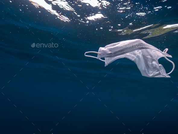 Medical face mask floating underwater. Used surgical mask on ocean ...