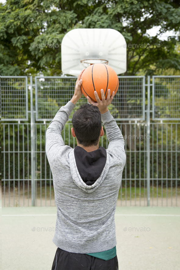 Man throwing a ball to the basket in a basketball court Stock Photo by ...