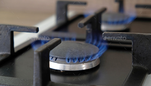 Close-up blue flames of fire on a gas burner in the kitchen for cooking ...