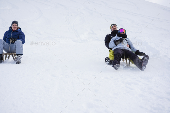 Crazy happy friends having fun with sledding on snow high mountains ...