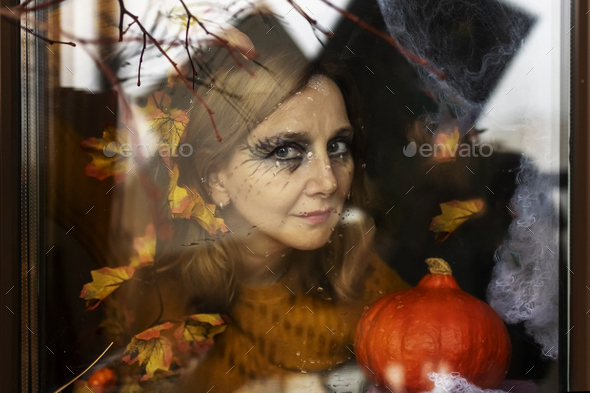 Scary witch woman outside the window of Halloween decorations ...