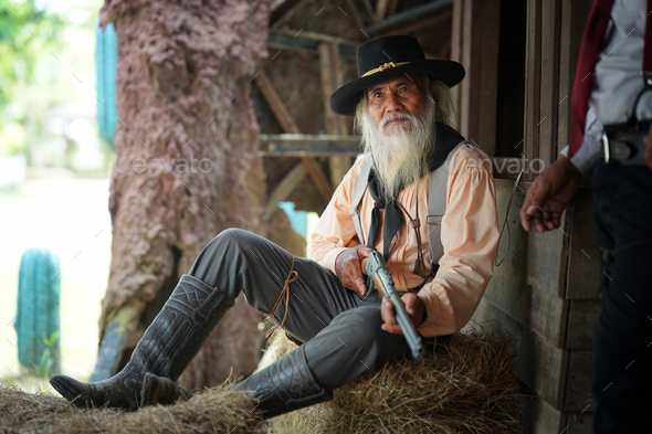 Brutal cowboy with his hand on revolver, wild west Stock Photo by ...
