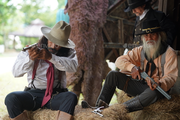 Brutal cowboy with revolver, gunfight on ranch, rural background. Stock ...