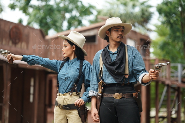 Brutal cowboy with revolver, gunfight on ranch, rural background. Stock ...