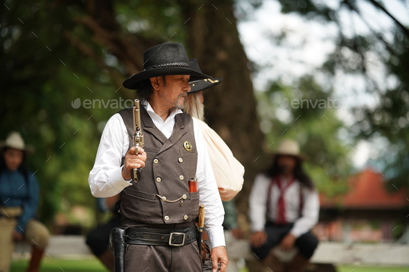 Brutal cowboy with revolver, gunfight on ranch, rural background. Stock ...
