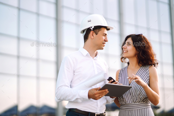 Two workers in a helmet at a work object discuss working issues. Stock ...