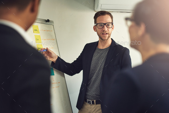 Shot of a young man giving a presentation to colleagues in an office ...