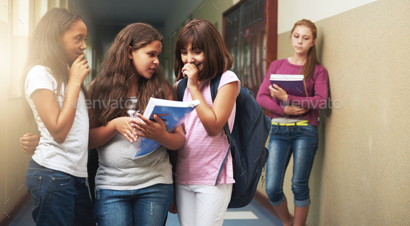 Bullying hurts. Shot of a young girl getting teased at school. Stock ...