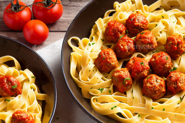Pasta fettuccine with meatballs sauce in black bowl. Cinematic background. Close up. Top view ...