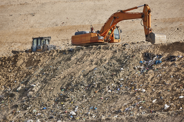 Open air garbage dump and excavator. Recycling junk. Global warming ...